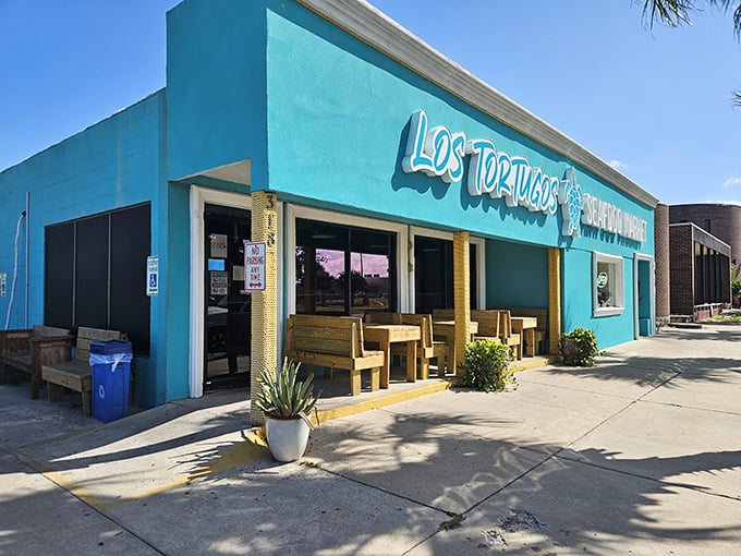 Los Tortugos' vibrant turquoise building stands out like a tropical fish in Port Isabel's landscape.