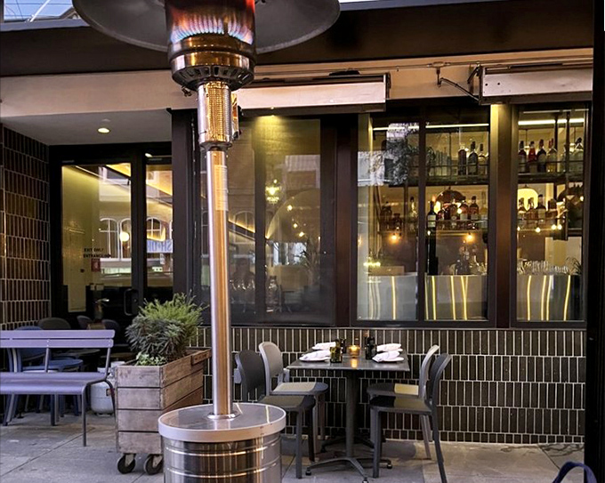 Delfina's sleek storefront whispers sophistication while the wood-fired oven inside roars with authentic Italian passion. 