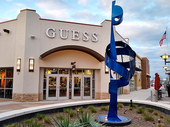 That striking blue sculpture adds artistic flair to serious shopping, proving outlets can be beautiful too. 