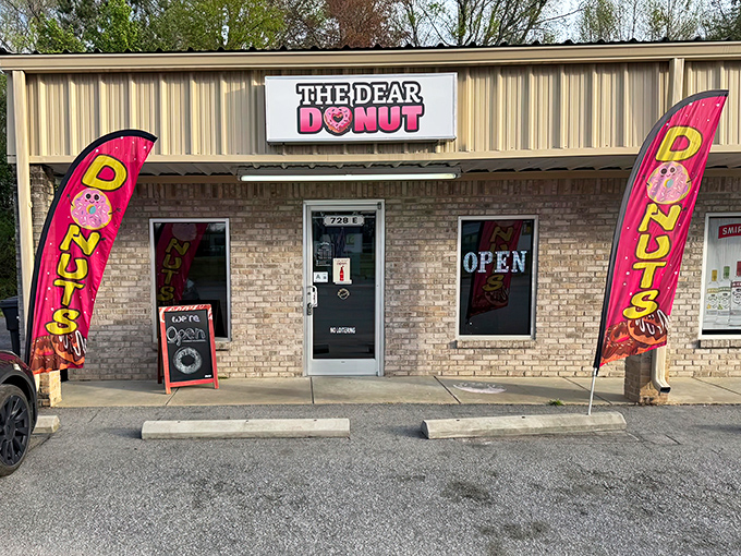 The Dear Donut's pink flags flutter like sweet surrender signals, calling you to abandon your diet for just one delicious morning.
