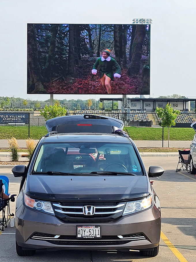 Elf in summer? Yes please! This minivan's tailgate view at Milky Way Drive-In offers Will Ferrell's woodland dash with stadium-style convenience.