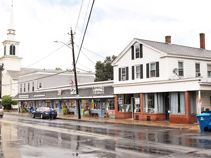 Puddle-perfect perspective! Monson's church steeple watches over storefronts where $1,200 monthly feels like winning the Massachusetts lottery without buying a ticket.