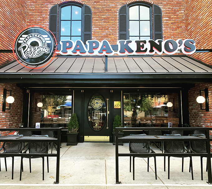 The classic storefront of Papa Keno's, where slices bigger than your face await. Folding skills required!