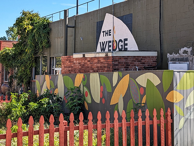 Fresh herbs and vegetables grow just steps from your pizza at The Wedge. That painted fence isn't just decorative&mdash;it's protecting future toppings!