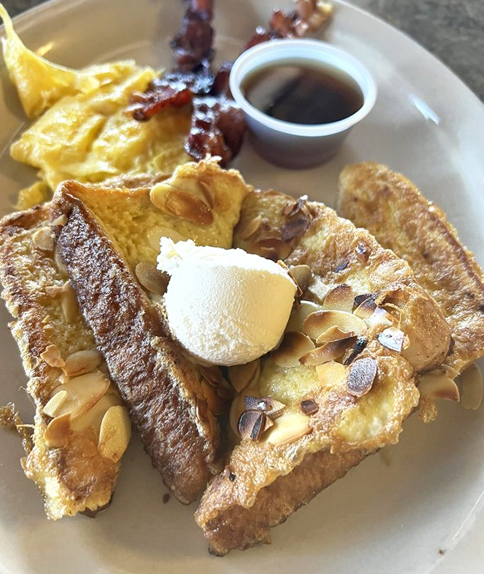 The almond-crusted French toast that launched a thousand return trips. Crispy, custardy, and crowned with a dollop of butter – breakfast royalty.