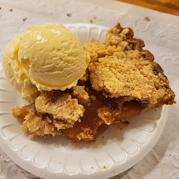 Apple pie with crumble topping and melting ice cream&mdash;proof that happiness isn't complicated, it just needs the right crust-to-filling ratio.