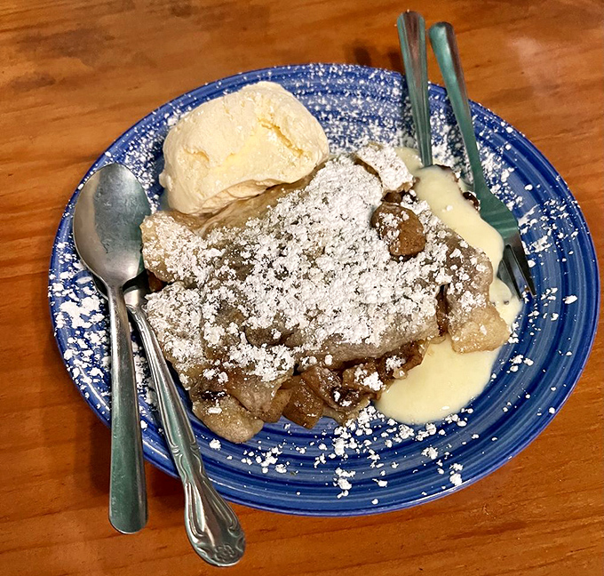 Dessert that demands a moment of silence. Apple strudel dusted with powdered sugar and served with vanilla ice cream&mdash;simple pleasures elevated to art.