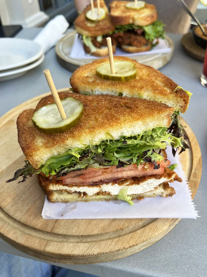 Not just any sandwich&mdash;a carefully constructed tower of crispy chicken, fresh greens, and that pickle spear standing guard like a delicious sentinel.