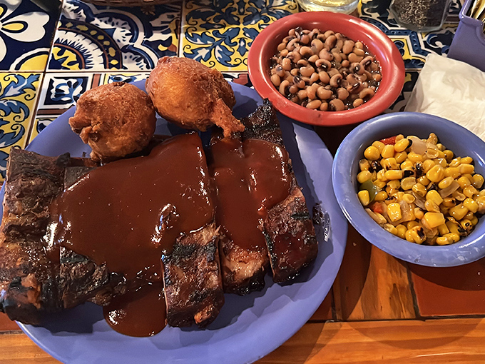 Baby back ribs glistening with sauce, flanked by corn fritters and baked beans&mdash;a holy trinity of Southern comfort that demands elastic waistbands.