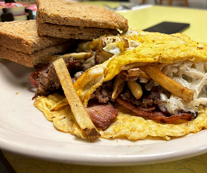 Behold the holy trinity of diner perfection: crispy fries, melted cheese, and bacon that would make even your cardiologist consider a cheat day.