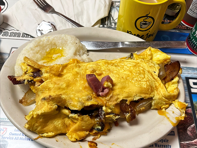 Bacon strips lounging on that omelet like they own the place &ndash; and honestly, they kind of do.