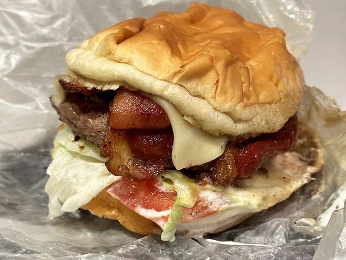 Burger bliss in every bite! This towering creation with bacon, cheese, and fresh veggies is the ultimate comfort food indulgence.