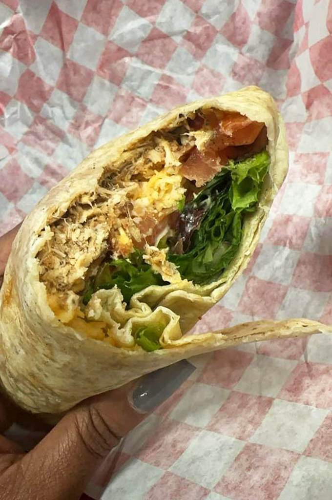 This wrap isn't just holding ingredients; it's cradling a perfect balance of chicken, greens, and spices like a culinary lullaby.