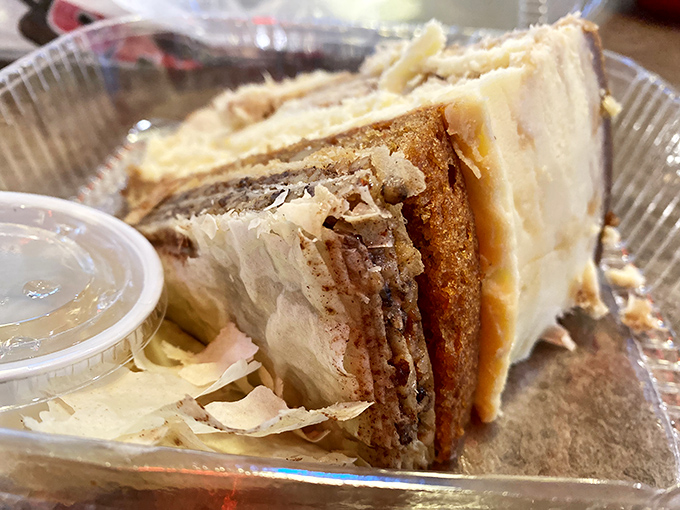 This slice of heaven isn't just carrot cake—it's an architectural marvel of moist layers, creamy frosting, and nutty exterior that demands to be savored.