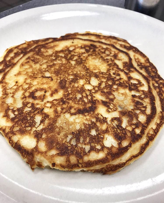 The golden-brown pancake perfection that inspired that bold window claim &ndash; crispy edges, fluffy center, and ready for its syrupy baptism.