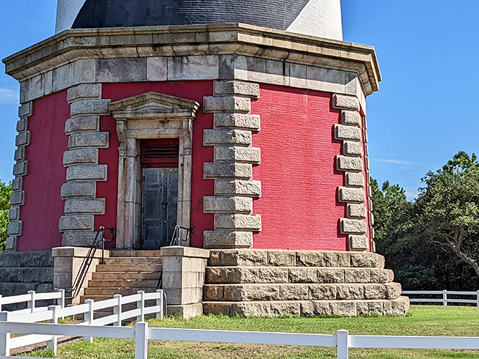 The lighthouse's ornate brick base showcases Victorian-era craftsmanship, with its distinctive red foundation providing dramatic contrast to the spiraling tower above.