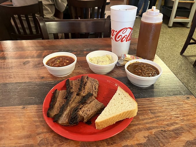 Brisket sliced thick enough to showcase its perfect smoke ring, flanked by sides that know their supporting role yet somehow still manage to steal scenes.
