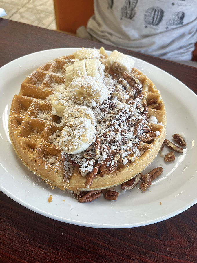 This isn't just a waffle&mdash;it's an edible pedestal showcasing pecans, powdered sugar, and butter melting into those perfect golden squares.
