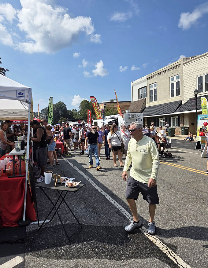 Locals and visitors alike stroll through the Big Red Apple Festival, hunting for treats and treasures under the Georgia sun. 