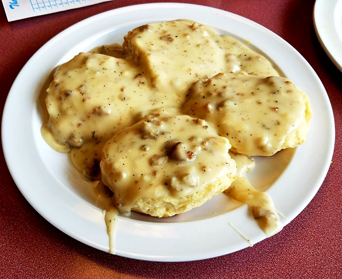 Biscuits drowning in creamy sausage gravy represent everything right about Southern breakfast traditions, no apologies necessary.