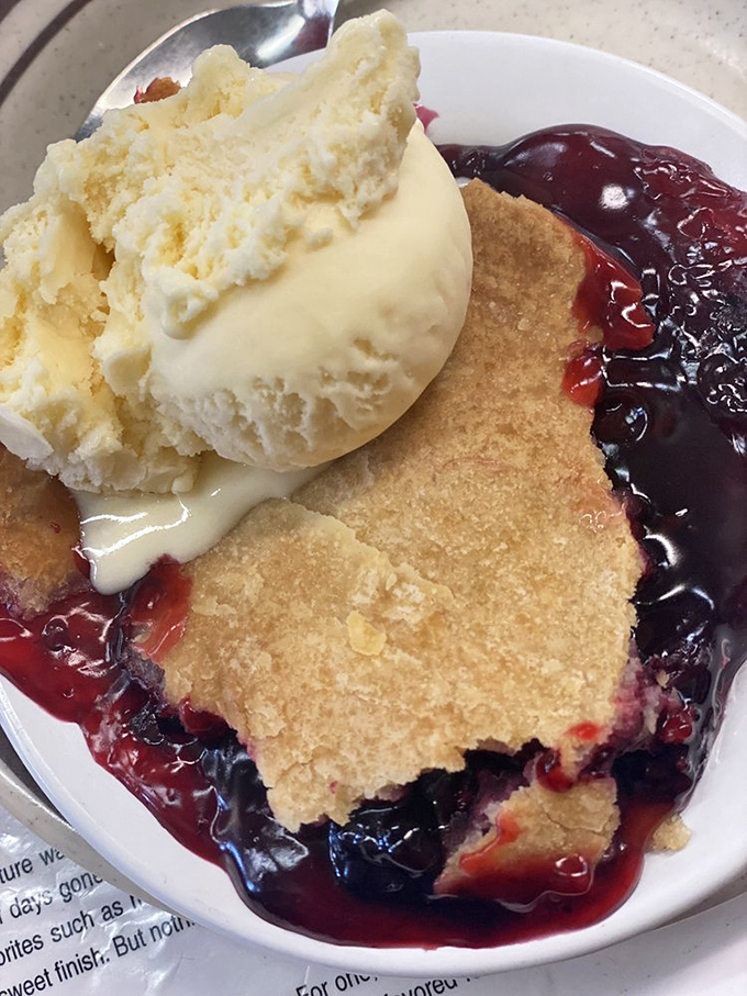 Berry cobbler that strikes the perfect balance between sweet and tart, topped with ice cream melting into those warm, bubbling juices.