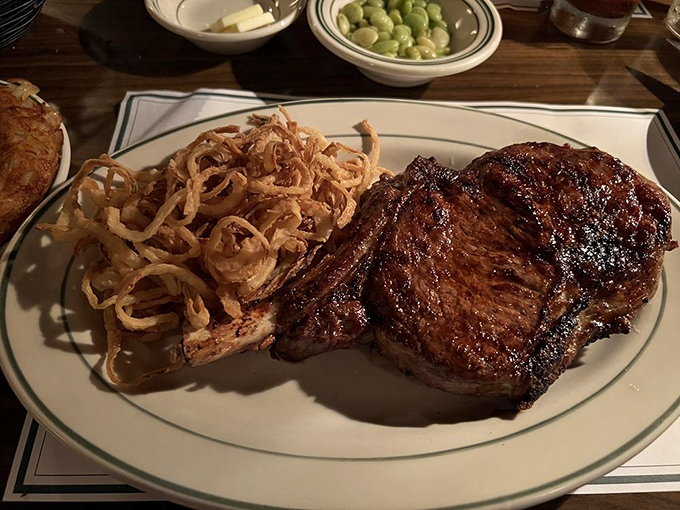The bone-in ribeye: where flavor goes to party. Those crispy onion strings aren't just a side&mdash;they're the world's most delicious nest.