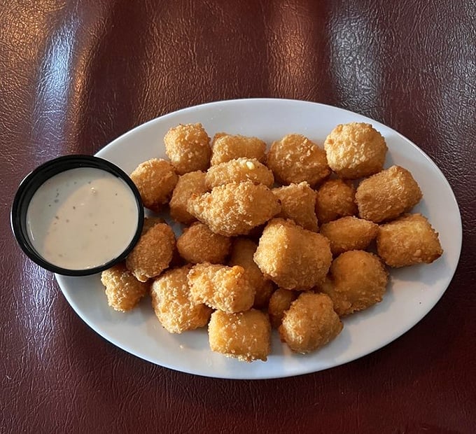 Wisconsin cheese curds—the state's unofficial currency. Breaded, fried to golden perfection, and served with ranch dressing that could make cardboard taste delicious.