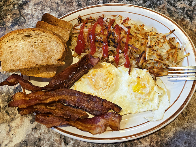 Breakfast perfection on a plate&mdash;crispy hash browns, eggs with sunset-yellow yolks, and bacon that makes you question why you'd eat anything else.