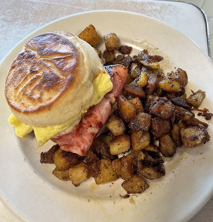 Breakfast sandwich architecture at its finest&mdash;a masterclass in morning engineering with that perfect ratio of egg, meat, and English muffin.