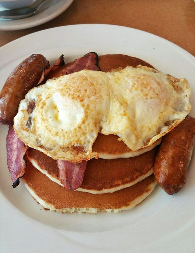 Behold the breakfast of champions: pancakes, eggs, bacon, and sausage arranged in a formation that says "nap time will be happening shortly."