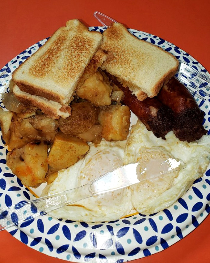Breakfast perfection on a blue-patterned plate &ndash; golden home fries, perfectly cooked eggs, and toast ready to sop up every last bit of yolk.