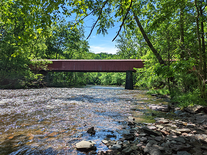 The historic bridge frames the creek like a masterpiece. Generations have crossed here, each footstep adding to Ralph Stover's living history.