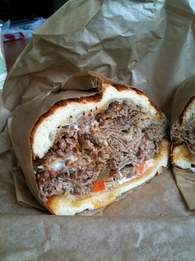 The brisket sandwich, wrapped in its paper cocoon, reveals tender, slow-cooked meat that's spent more time perfecting itself than most of us spend at the gym.