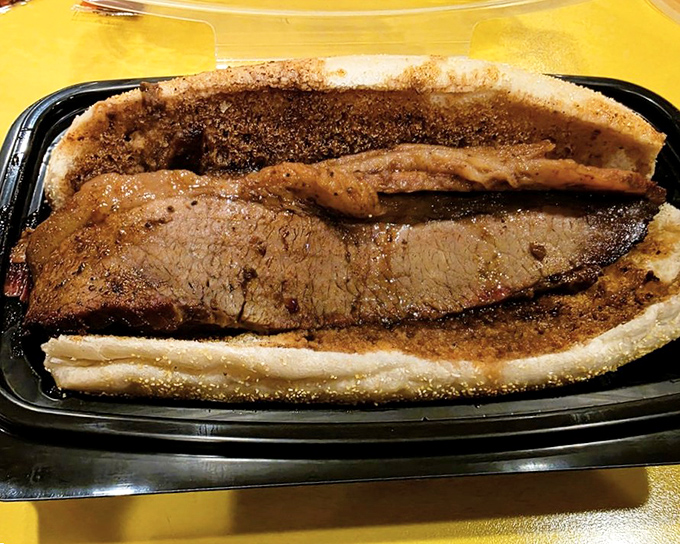 Brisket sliced thick enough to remind you it once had purpose, nestled in a soft bun that's merely transportation for the star of the show.