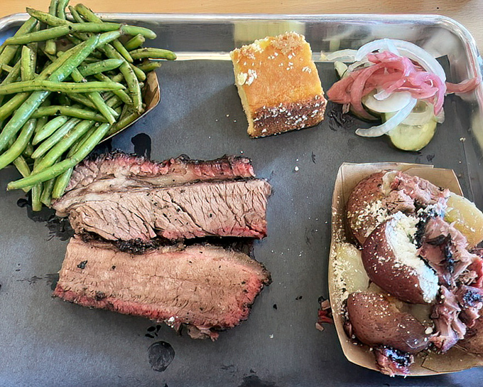 Brisket sliced with the reverence it deserves, alongside green beans and cornbread. This tray is the barbecue equivalent of a standing ovation.