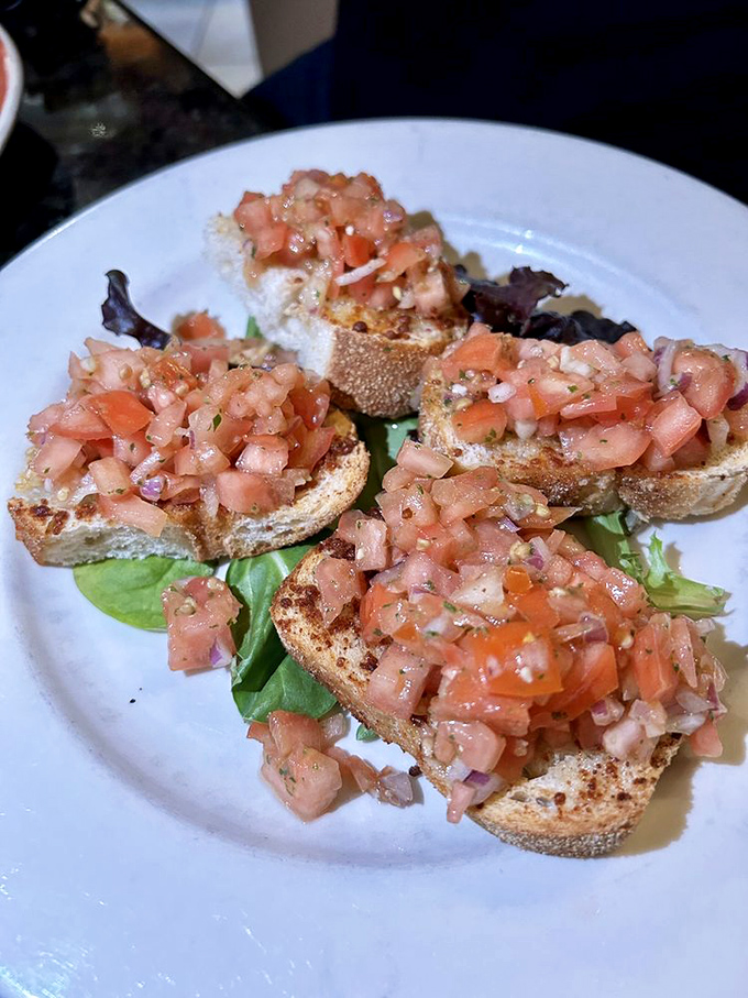 The bruschetta that launched a thousand cravings: perfectly toasted bread topped with tomatoes so fresh they might have been picked minutes ago.