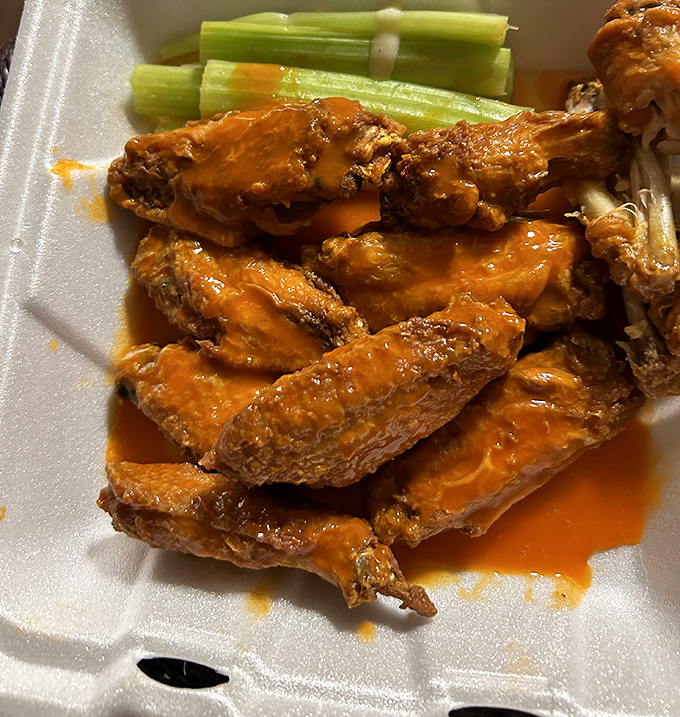 Buffalo wings that mean business—crispy, saucy, and served with the obligatory celery sticks that we all pretend count as our vegetable serving.