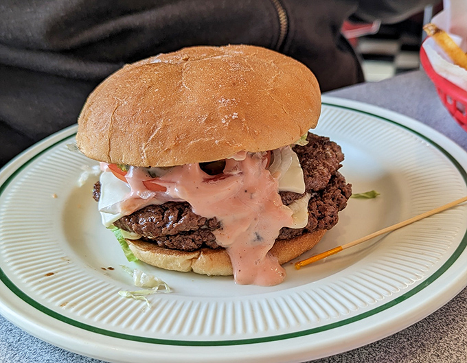 This isn't just a burger; it's a towering monument to beef with special sauce cascading down its sides like delicious lava.