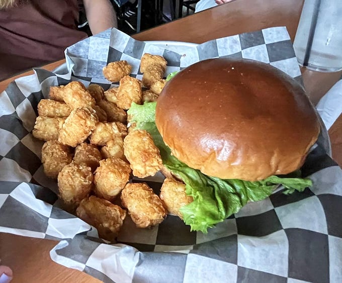This burger's presence commands attention, while those golden tots stand by like delicious little soldiers.