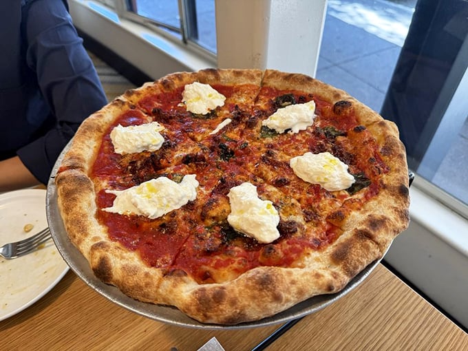 Fresh burrata dollops crown this tomato-sauced beauty like clouds resting on a delicious, blistered landscape of carbohydrates.