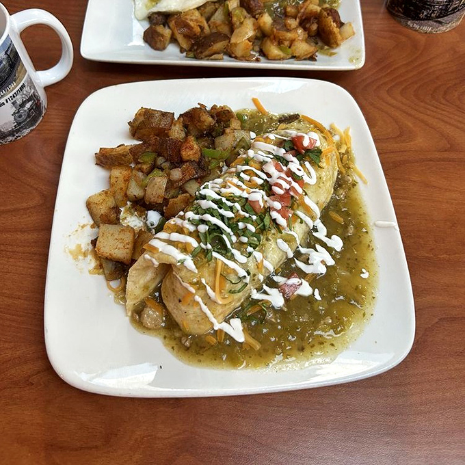 Green chili transforms this burrito from mere breakfast to morning masterpiece. That drizzle of sour cream is the artist's signature on a culinary canvas.