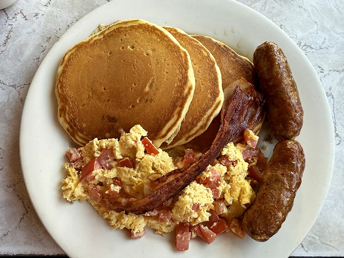 Three pancakes, two sausages, scrambled eggs, and bacon &ndash; because sometimes more really is more, and that's beautiful.