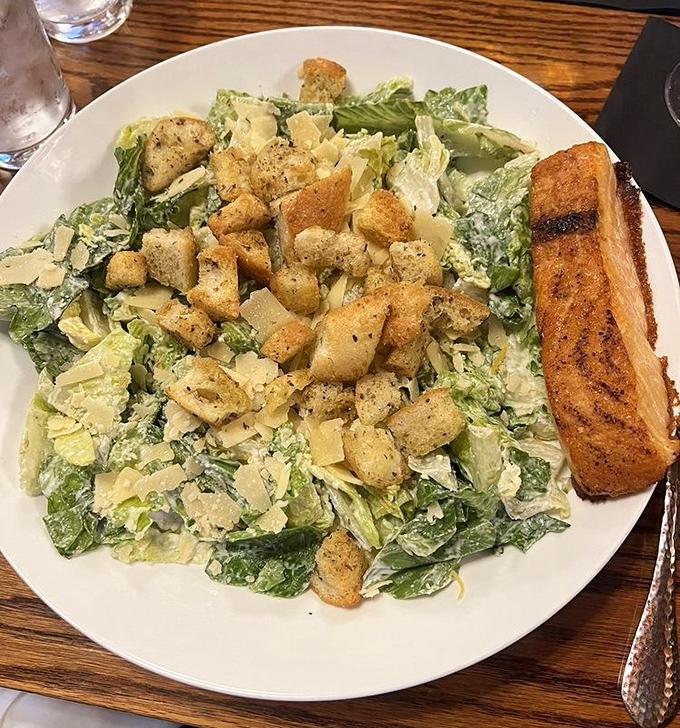 This Caesar salad isn't just playing a supporting role &ndash; it's stealing scenes with crisp romaine, generous parmesan, and garlic bread worthy of applause.