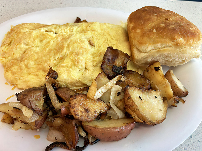 An omelet so fluffy it could practically float away, paired with potatoes that have achieved that perfect crisp-tender harmony.