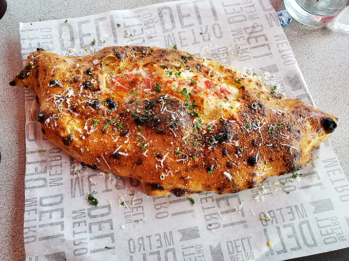 This isn't just a calzone; it's a golden-brown treasure chest filled with molten cheese and savory fillings.