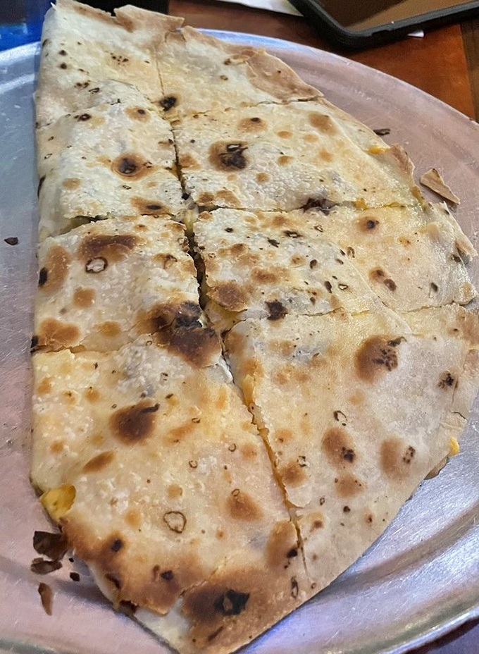 That quesadilla isn't just cooked—it's been kissed by fire, leaving those perfect char marks that whisper "authenticity" with every bite.