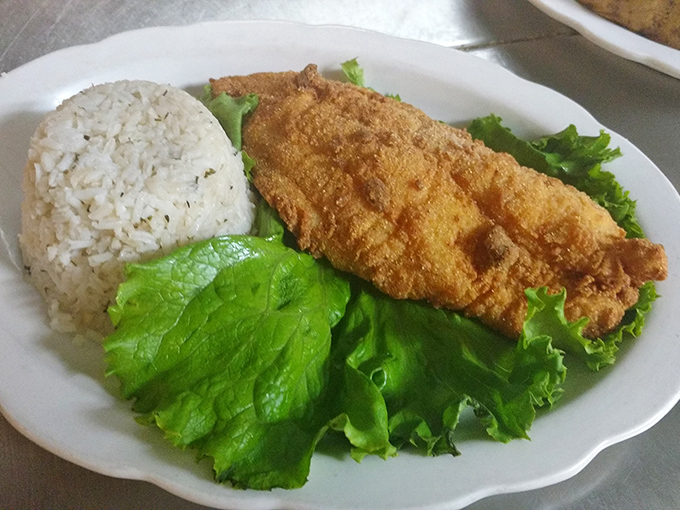 Golden-fried catfish perched atop a bed of rice and greens&mdash;proof that even landlocked Kansas knows its way around seafood.