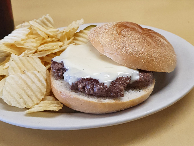 Simple pleasures done right: a classic burger on a kaiser roll with melty cheese, served with chips &ndash; proof that sometimes less really is more.