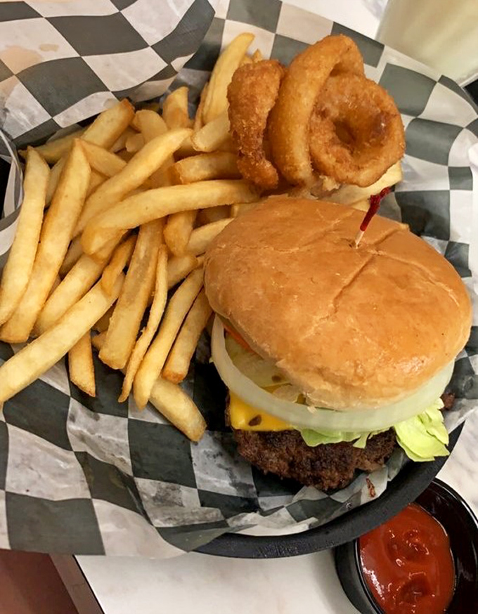A classic American cheeseburger that doesn't need fancy tricks &ndash; just honest ingredients stacked between a perfectly toasted bun, with crispy fries and onion rings playing the perfect supporting roles.