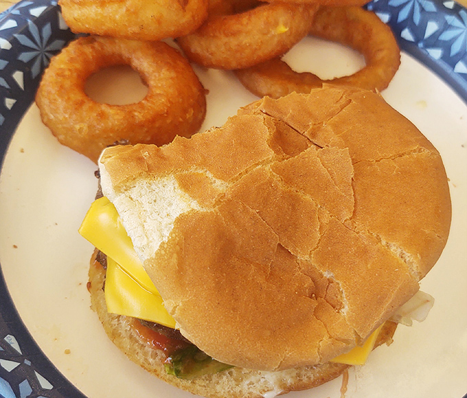 This isn't just a cheeseburger—it's edible architecture where every layer knows its role. The onion rings standing guard are a nice touch.